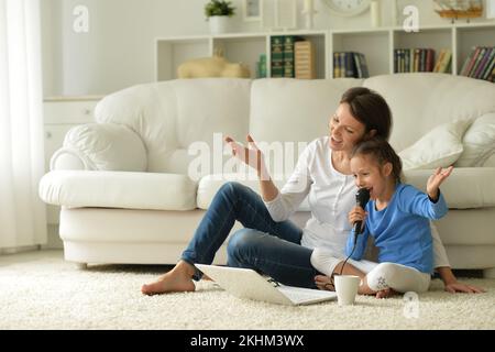 mom and daughter sing into the microphone with a laptop Stock Photo - Alamy