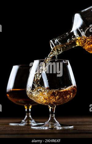 Whiskey is poured from a vintage bottle into a frozen glass with ice ...