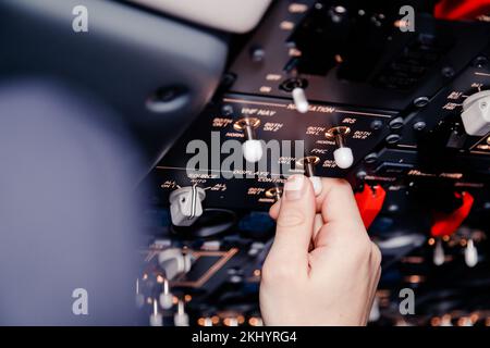 Pilot hand is controlling plane toggle switches to fly take off and ...