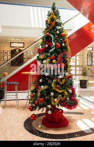 Christmas tree with yellow garlands, decorative bulbs and big white ...