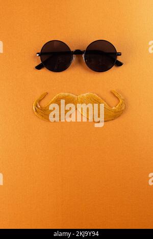 Composition of fake moustache and glasses on orange background with ...