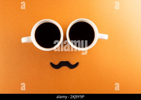 Composition of fake moustache and cups of coffee on orange background ...