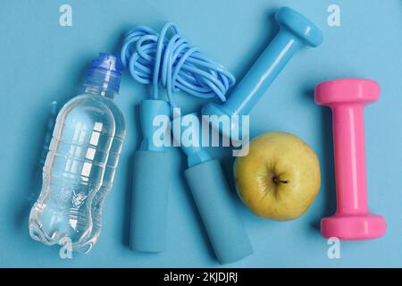 Jump rope, apple and barbells next to water bottle Stock Photo - Alamy