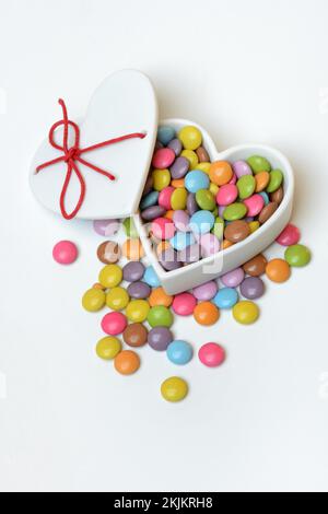 Chocolate lentils in heart-shaped container, Smartie Stock Photo - Alamy