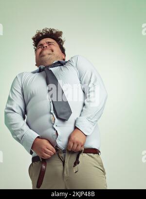 Crazy funny businessman in curly wig doing horn sign on grey copy space ...