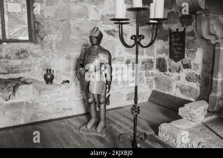 The grayscale view of a knight's armor displayed in a medieval building ...