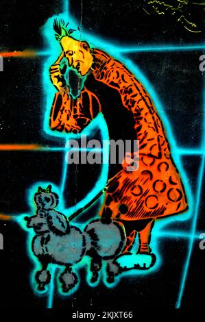 old man in a blue coat with the mobile phone sitting on the bench in a ...