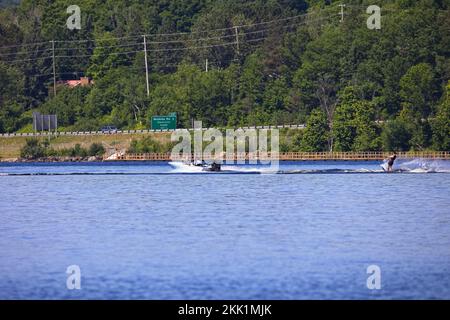 A water skier seen on Hunters Bay Lake while North bound traffic passes ...
