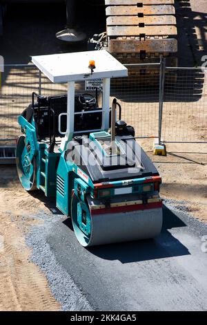 Road construction equipment flattening and smoothing asphalt black top ...