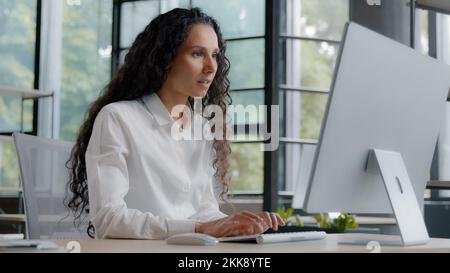 Young hispanic woman celebrating online birthday holding gift at home ...