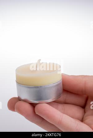 White color small Candle in hand on a white background Stock Photo - Alamy
