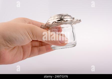 Little empty jar in hand on a white background Stock Photo - Alamy