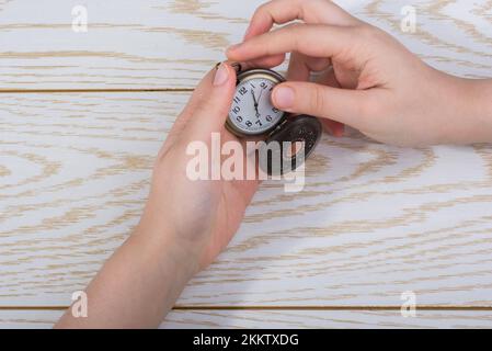 Retro style pocket watch in hand on black background Stock Photo - Alamy