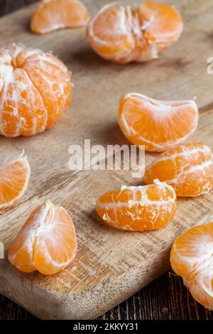 peeled ripe juicy tangerine, divided into slices of tangerine on a ...