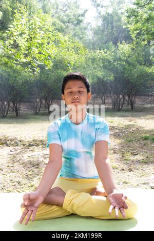 An indian boy doing yoga outdoors Stock Photo - Alamy
