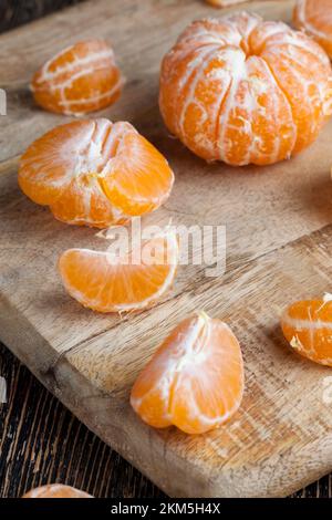 peeled ripe juicy tangerine, divided into slices of tangerine on a ...