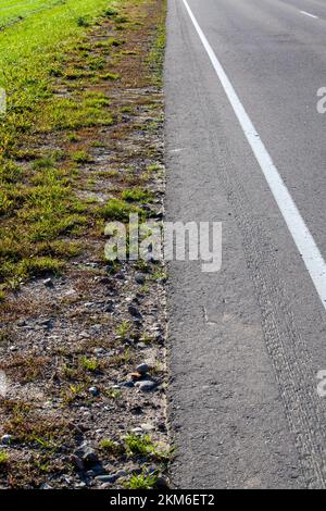 an empty old not paved road , road markings on an not asphalt highway ...