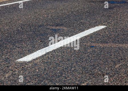 an empty old not paved road , road markings on an not asphalt highway ...