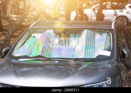 Protective reflective surface under windshield of car on hot day ...