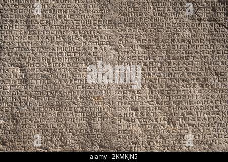 Ancient greek inscriptions on the wall of archeological ruins close-up ...