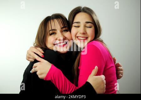 Mom and daughter are hugging they have a lot of tenderness and love for each other they strongly ...