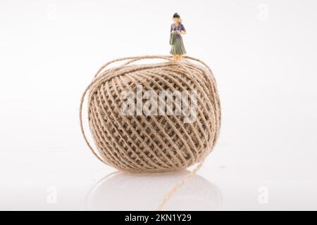 Woman figure at the top a linen spool of thread on a white background ...