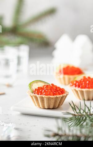 Festive Christmas appetizer tartlets stuffed with red caviar and a ...