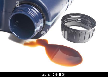 open engine oil bottle with a puddle of engine oil isolated on white ...