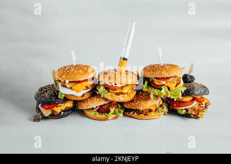 The delicious fresh and juicy burgers with syringe stacked on each ...