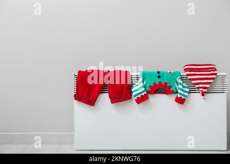 Baby elf costume drying on electric radiator near light wall Stock ...