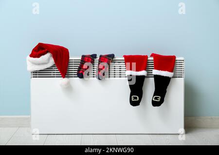 Baby Christmas bodysuit drying on electric radiator near yellow wall ...