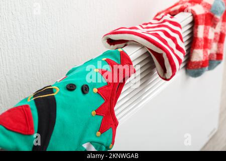Baby elf costume drying on electric radiator near light wall Stock ...