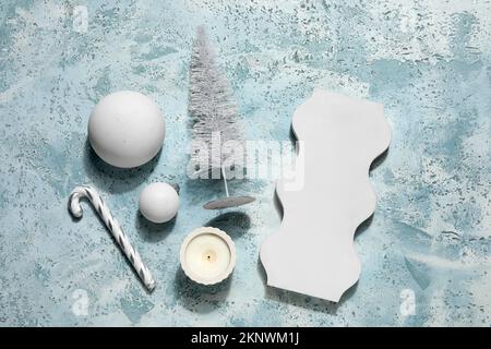 Christmas tree candle with podiums, candy canes and balls on beige ...