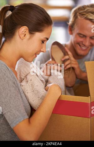 Happy young couple unpacking or packing boxes and moving into a new ...