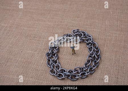 Man figurine trapped in the circle of a chain Stock Photo - Alamy