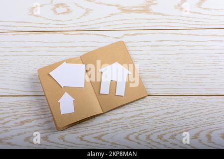 Little paper house on a notebook on parquet Stock Photo - Alamy