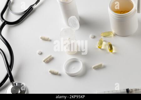 Composition of stethoscope with syringe and pills on white background ...
