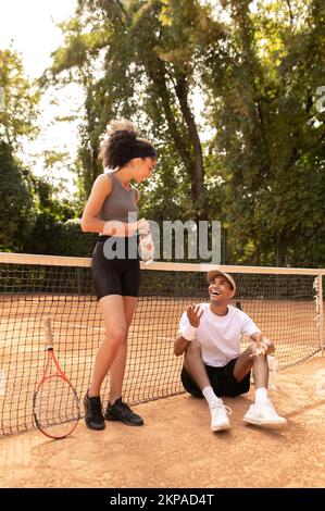Young tennis players talking after the game Stock Photo - Alamy