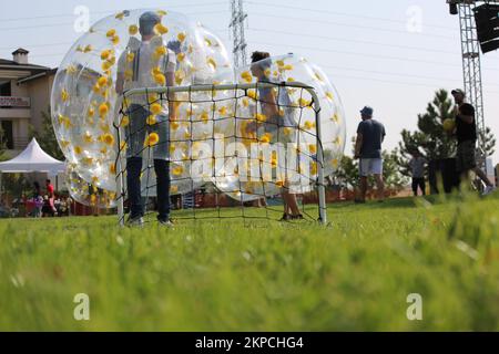 People playing bubble football at the festival area Stock Photo - Alamy