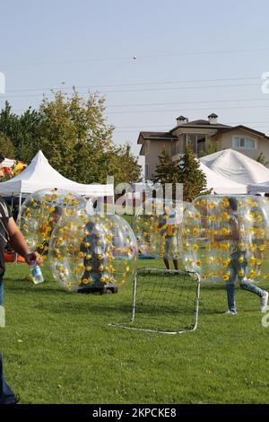 People playing bubble football at the festival area Stock Photo - Alamy