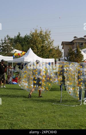 People playing bubble football at the festival area Stock Photo - Alamy