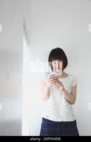 Young Japanese woman operating a mobile phone Stock Photo - Alamy