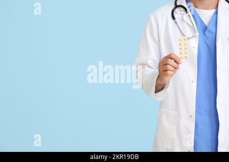 Male doctor with vitamins on blue background Stock Photo - Alamy