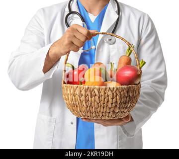 Male doctor holding basket with vegetables and vitamins on white ...