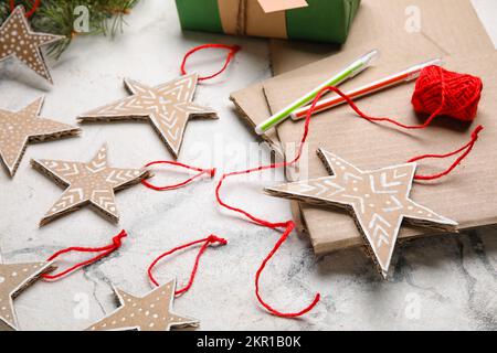 Christmas cardboard stars with threads on light background, closeup ...