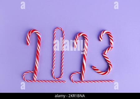 Sweet candy canes on lilac background Stock Photo - Alamy