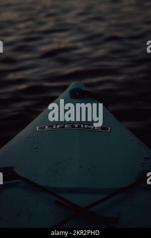 Blue Kayak Peacefully Floating in a Lake After Sunset Stock Photo - Alamy