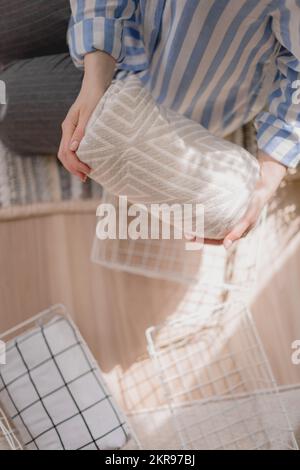 Modern housewife putting neatly folded towels, pillowcases, duvet ...