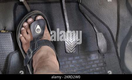 Close up foot wearing slipper push the brake and driving pedal old car ...