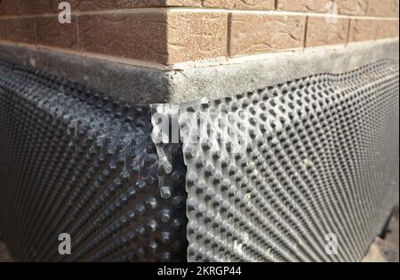 External house basement foundation wall insulation with rigid foam board before waterproofing ...